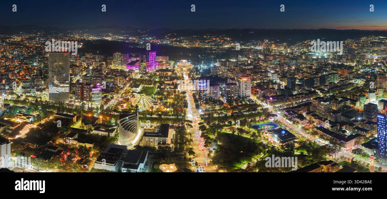 Aerial twilight view of Tirana skyline and city lights with illuminated ...