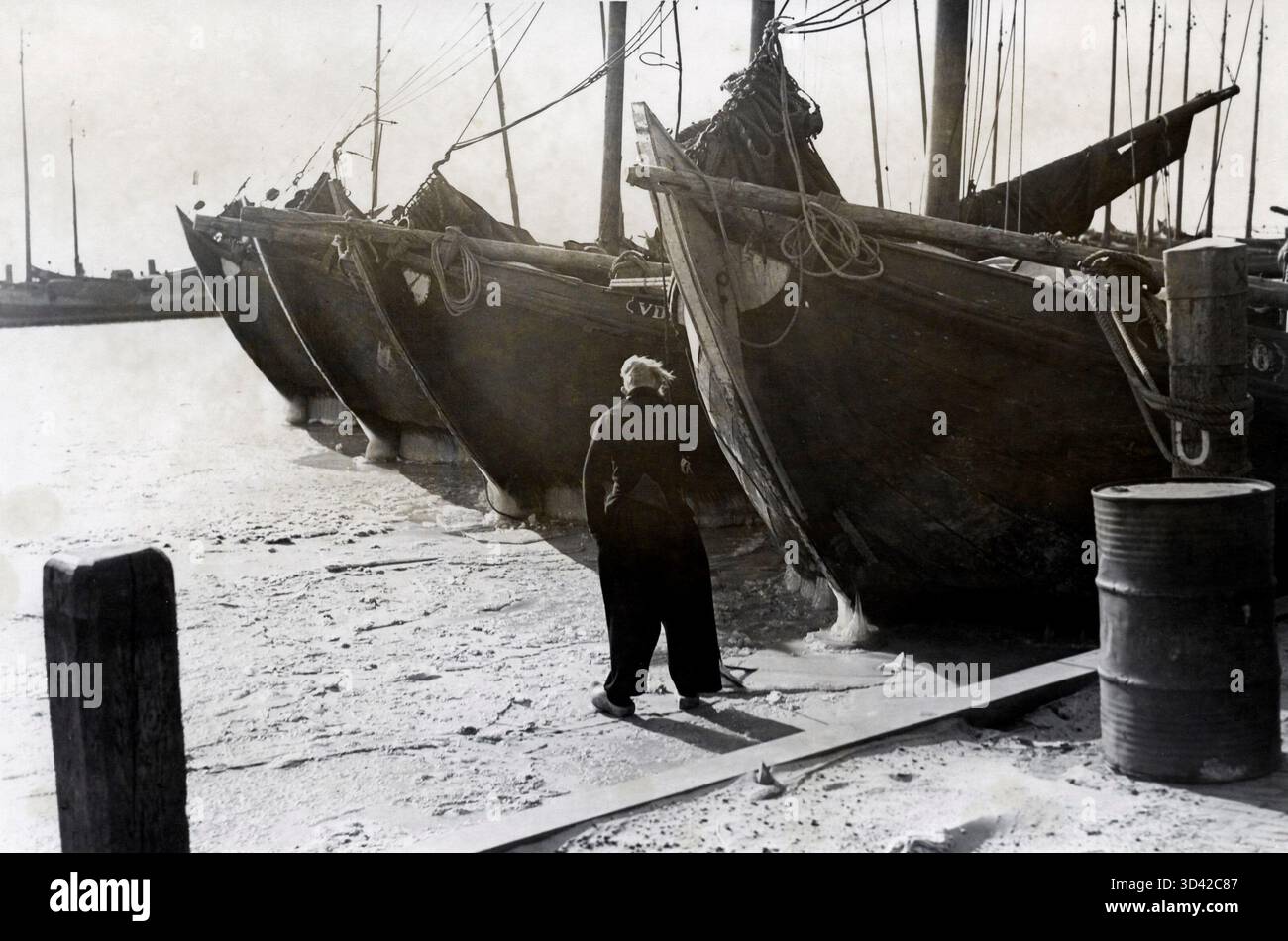 This photograph from 1929-1930 shows a frozen harbor in Volendam ...