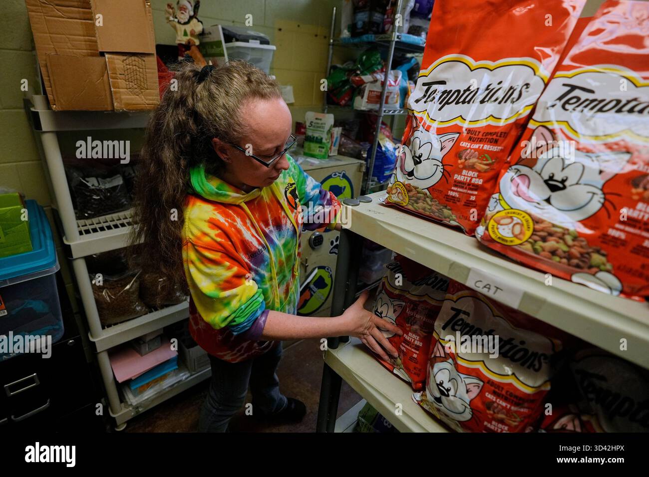 Jordan Robinson restocks a Pet food pantry, for families needing help ...