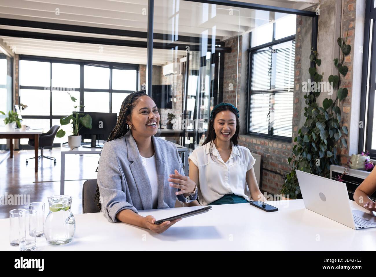 Colleagues in modern office celebrating success with laughter and ...