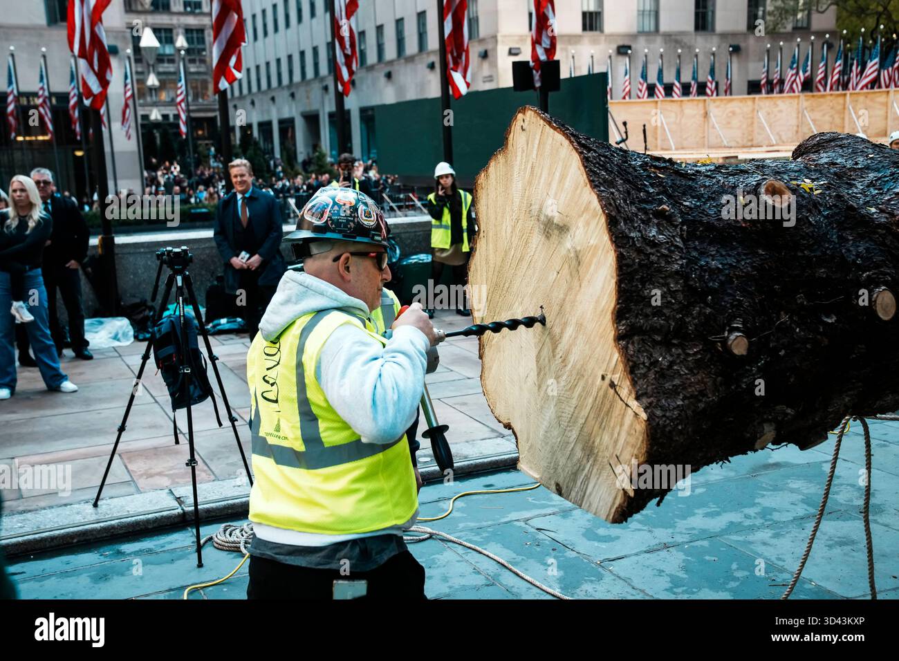 Workers pound a stake into the base of the Rockefeller Center Christmas ...