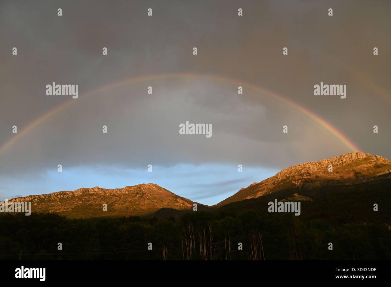 Dramatic Full Rainbow and Skyline of Golden Rocks Lit at Dusk with Dark ...