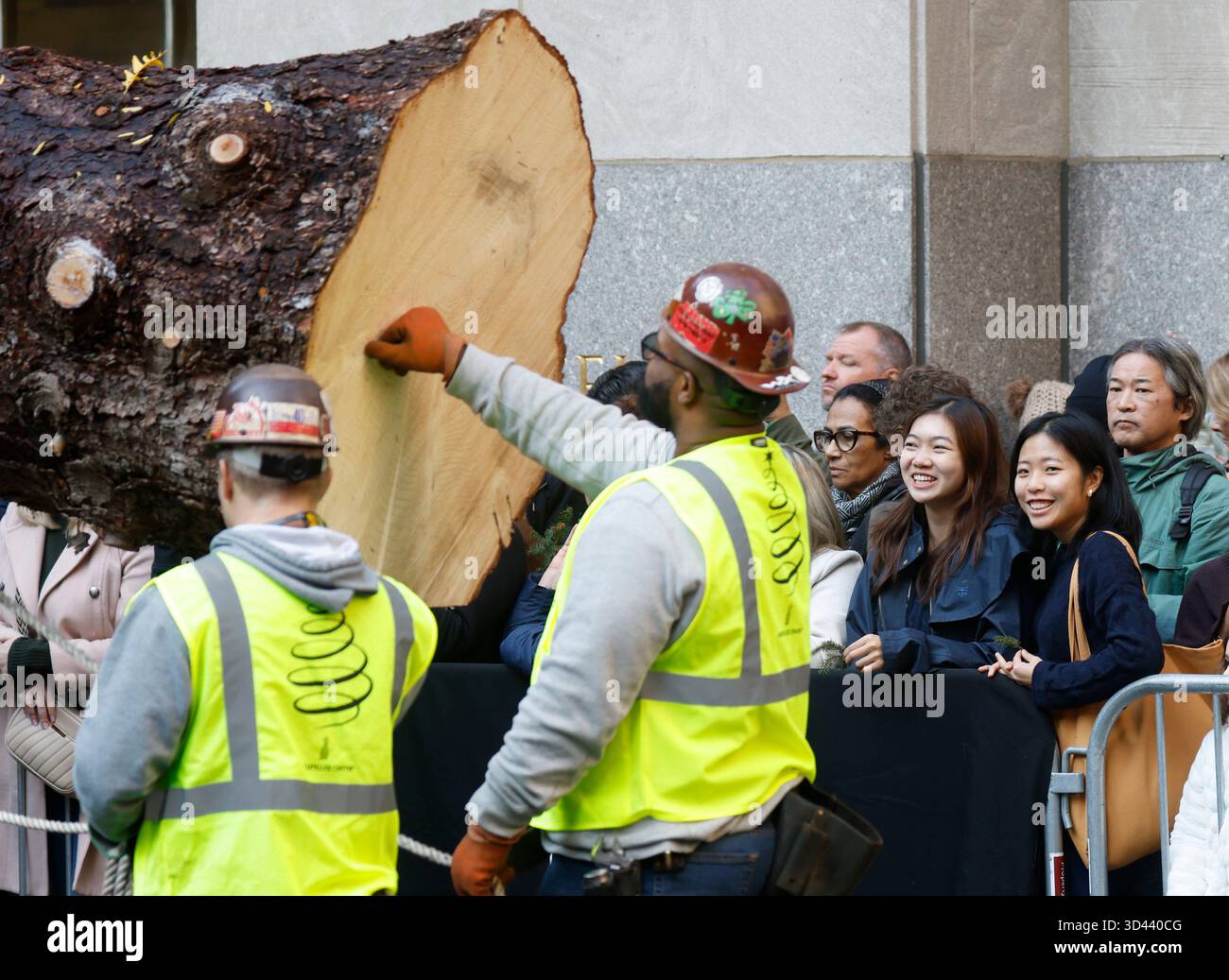 Spectators watch as workers prepare to lift into place by crane the ...
