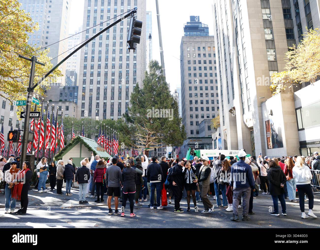 Spectators watch as workers lift into place by crane the Rockefeller ...