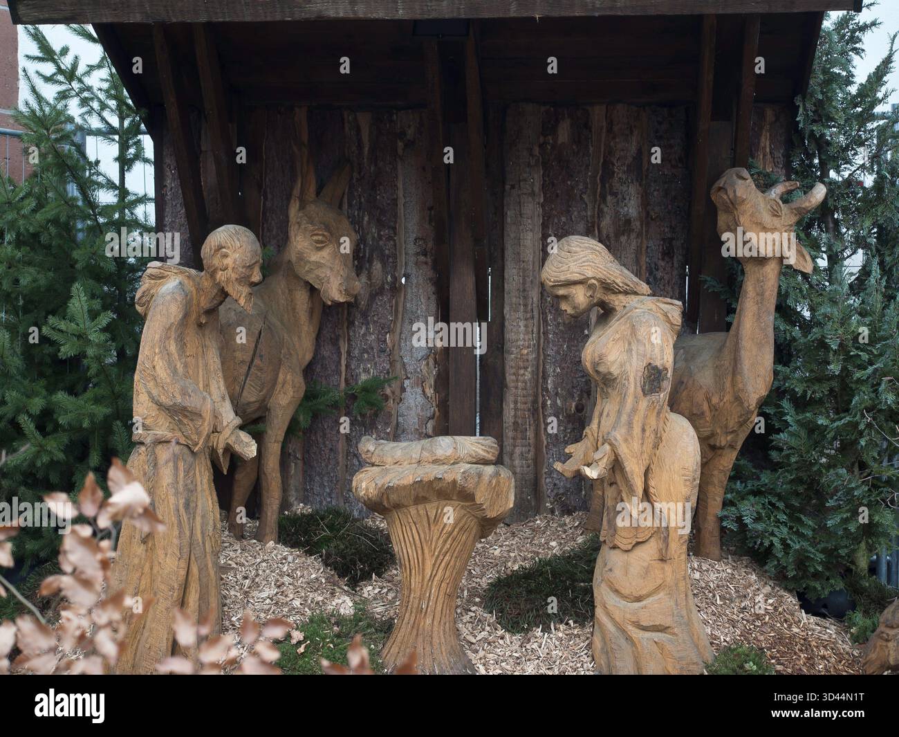 Wooden crib with religious figures and animals, depicted in a Christmas ...