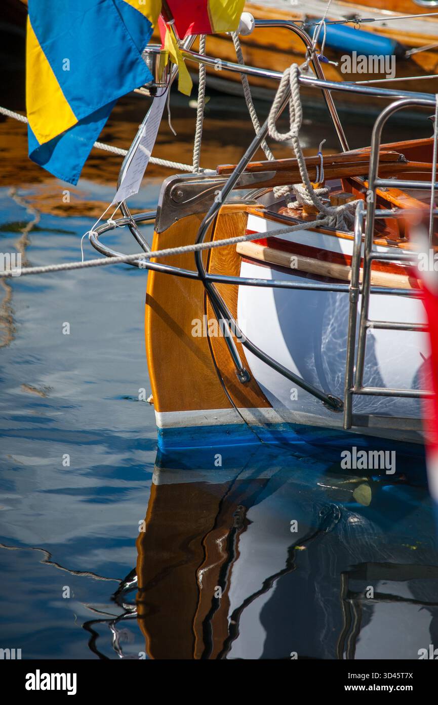 close-up of wooden sailboat stern with flags and reflections Stock ...