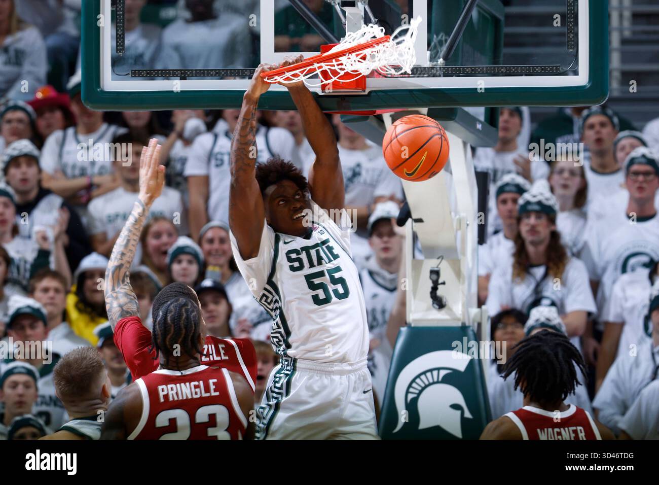 Michigan State forward Coen Carr (55) dunks against Arkansas forward Nick Pringle (23) during ...