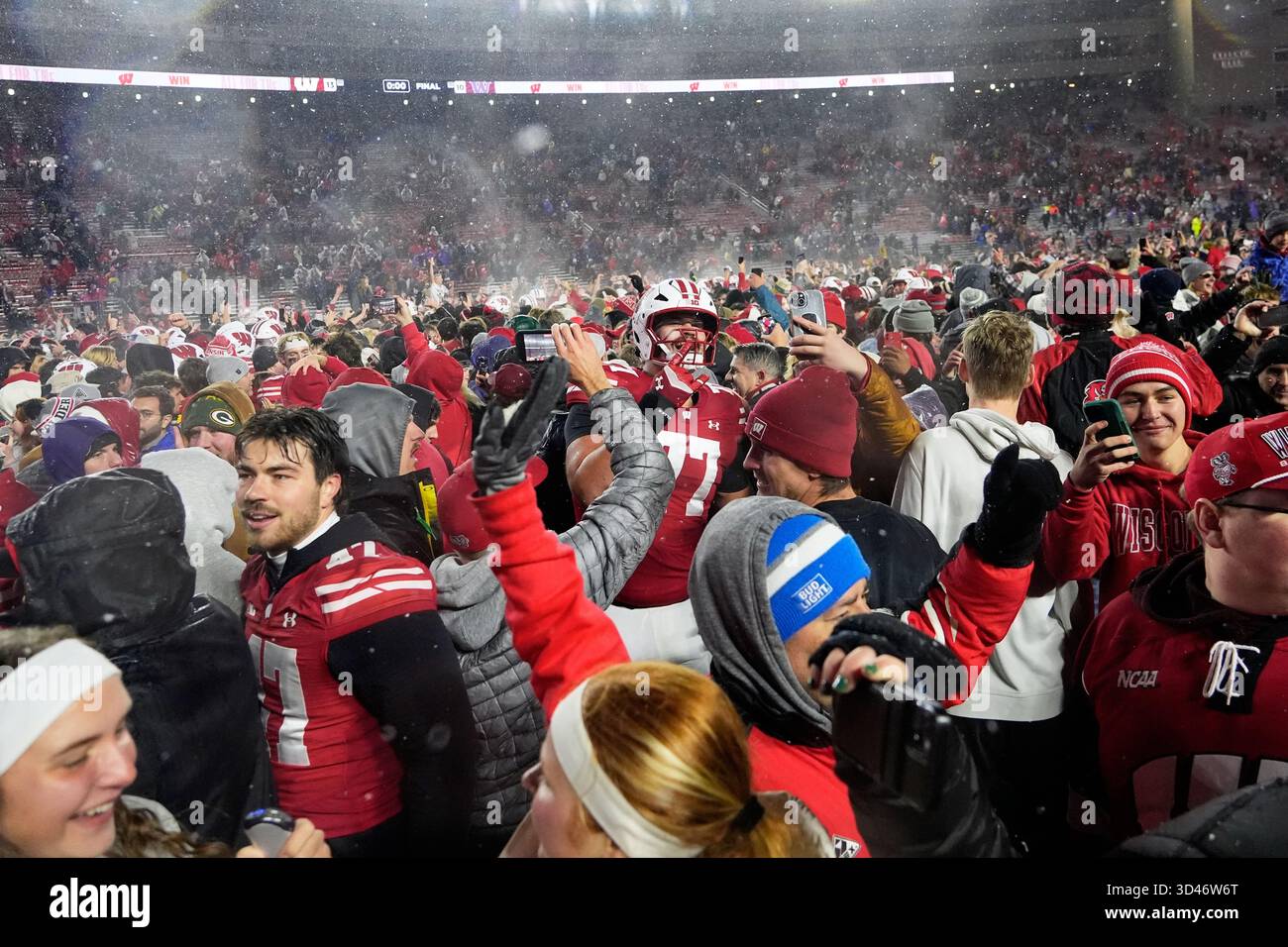 Wisconsin players celebrate as fans storm the field after an NCAA ...