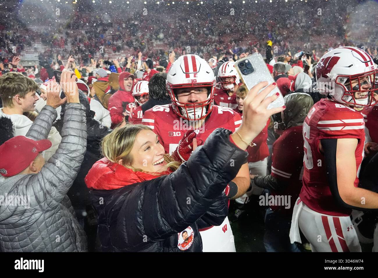 Wisconsin players celebrate as fans storm the field after an NCAA ...