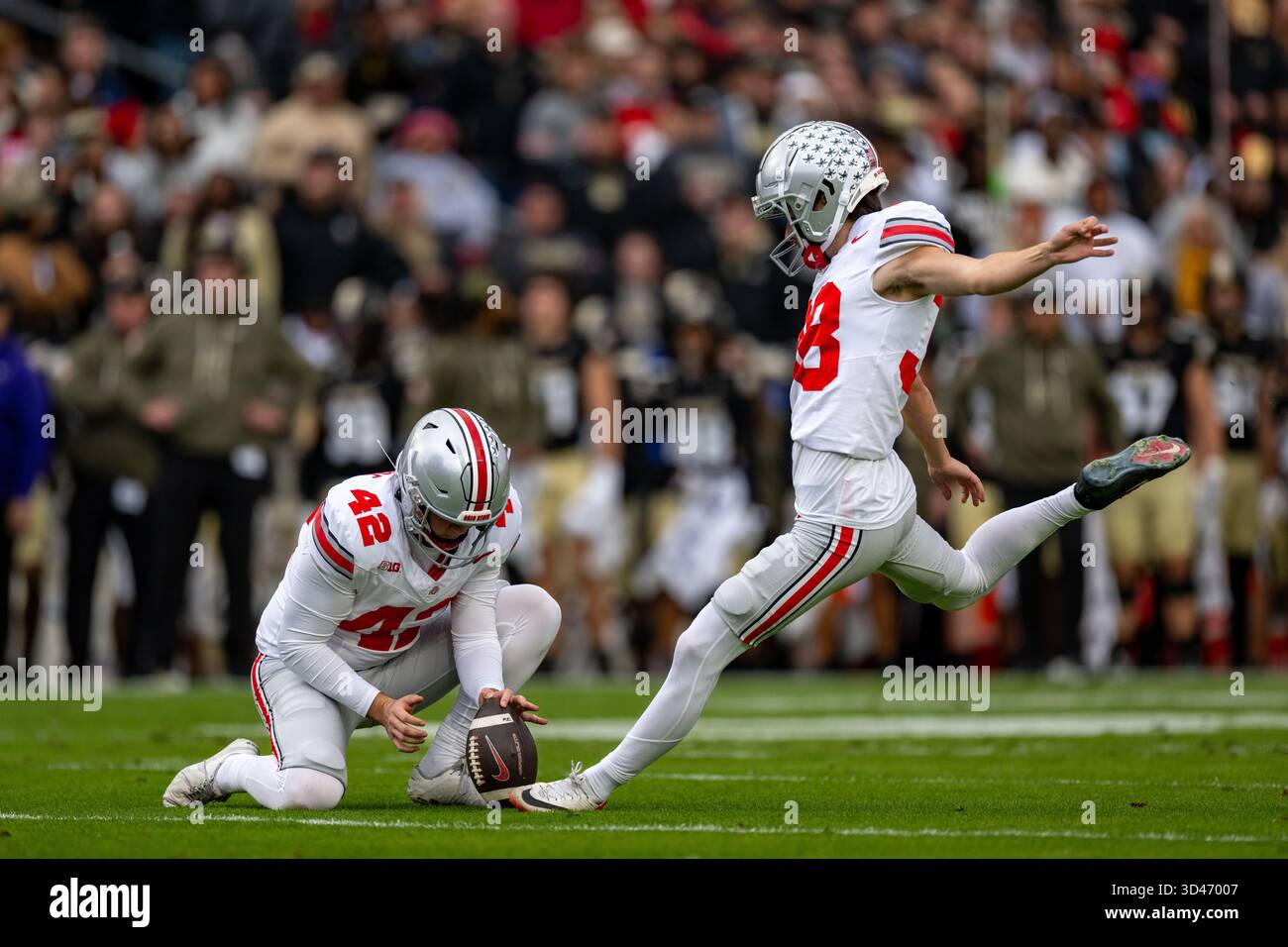 Ohio State kicker Jayden Fielding (38) kicks out of the hold of punter ...