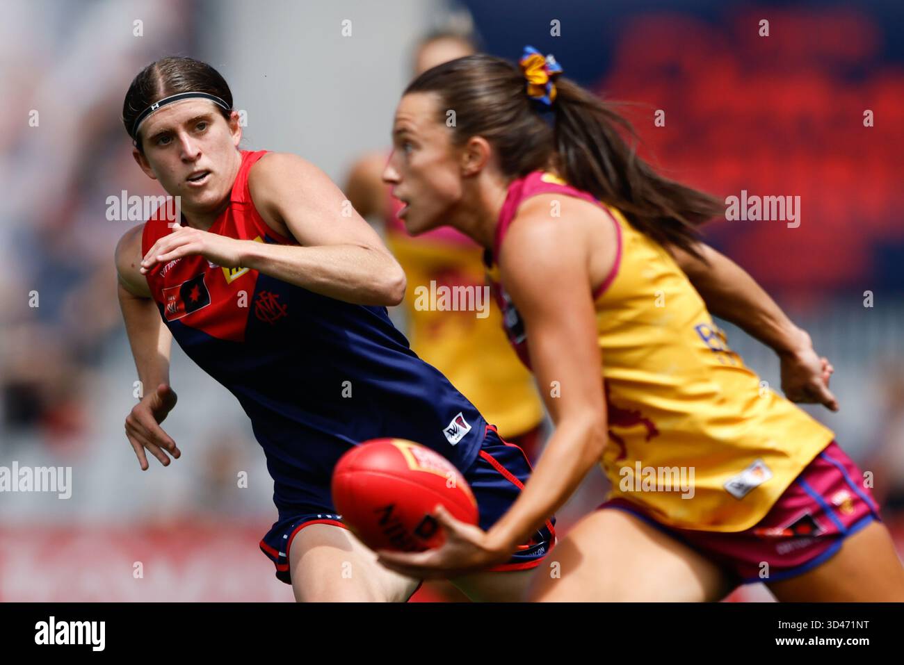 Ryleigh Wotherspoon of the Demons chases Jade Ellenger of the Lions ...
