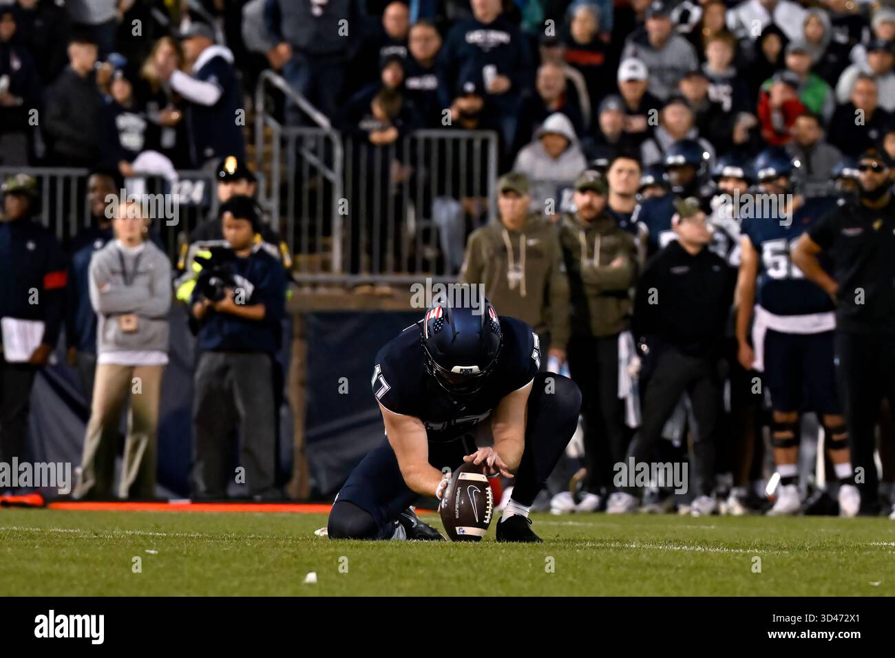 UConn punter Connor Stutz holds the ball for a field goal attempt ...