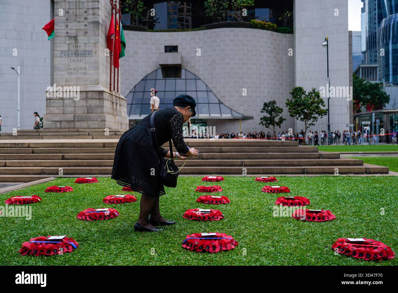 A woman taking picture of Remembrance Day flower circle placed on the ...