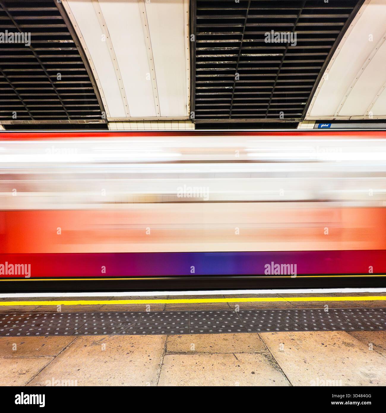 An Underground train moves along the station. Photographed with a very ...