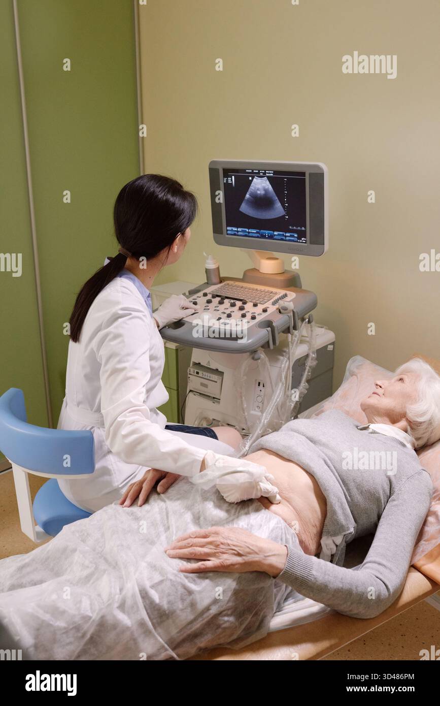Caucasian elderly woman having abdominal ultrasound in clinic. Female ...