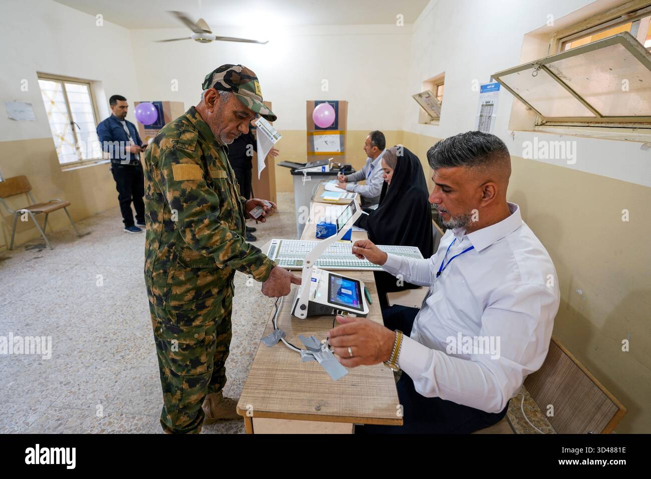 A member of the Popular Mobilization Forces casts his ballot during a ...