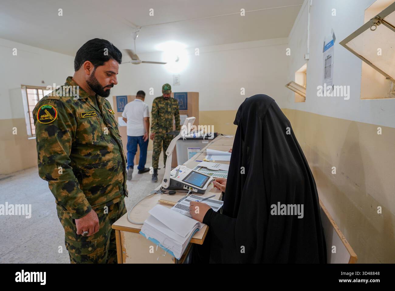 A member of the Popular Mobilization Forces casts his ballot during a ...