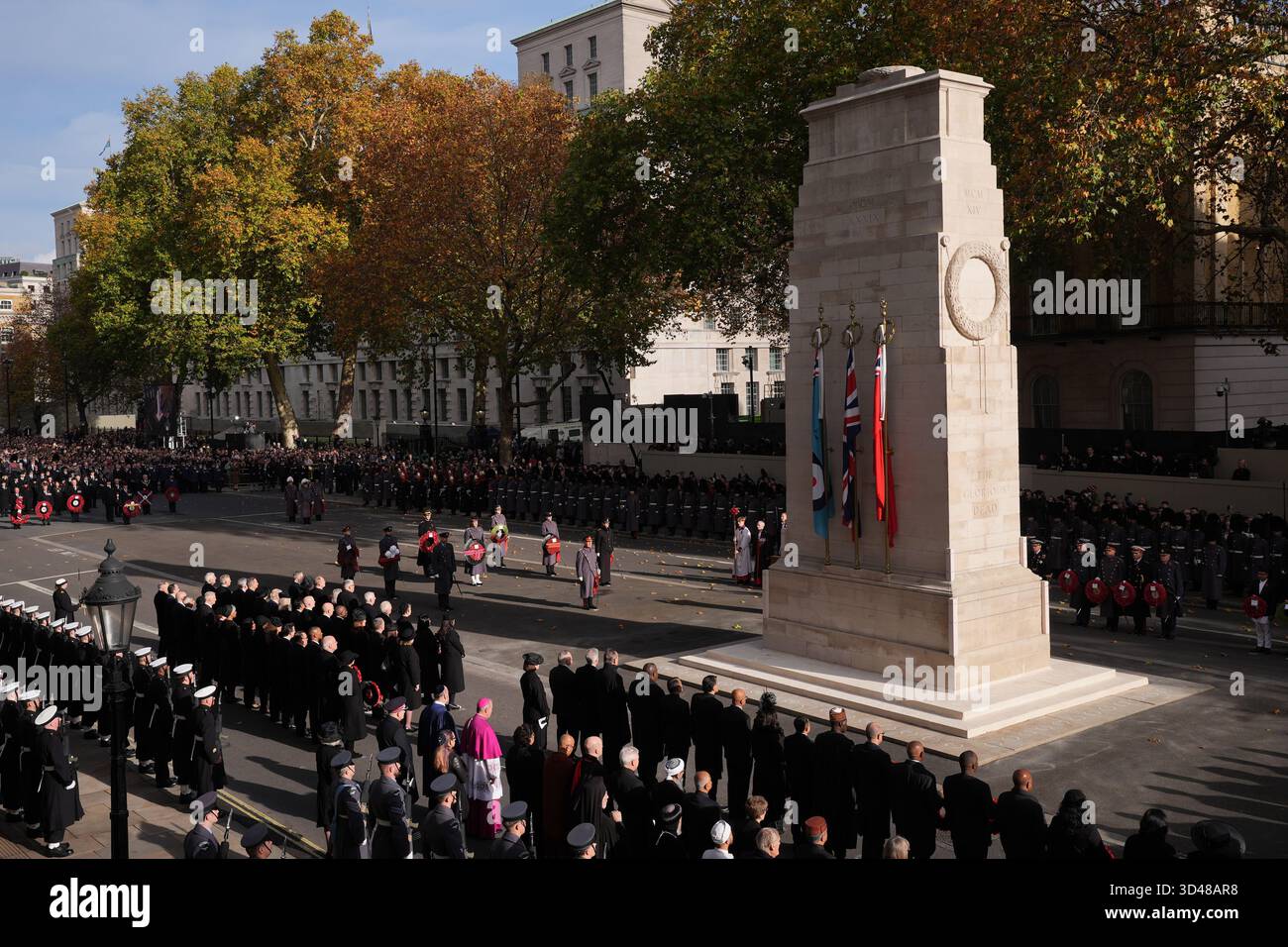 King Charles III (centre) stands during the Remembrance Sunday service ...