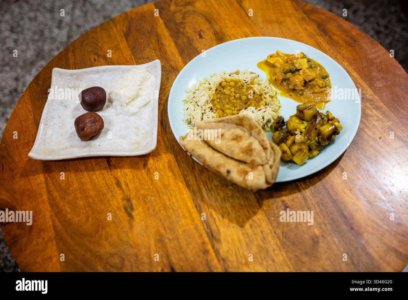traditional indian meal with mixed curries rice and chapati on dining ...