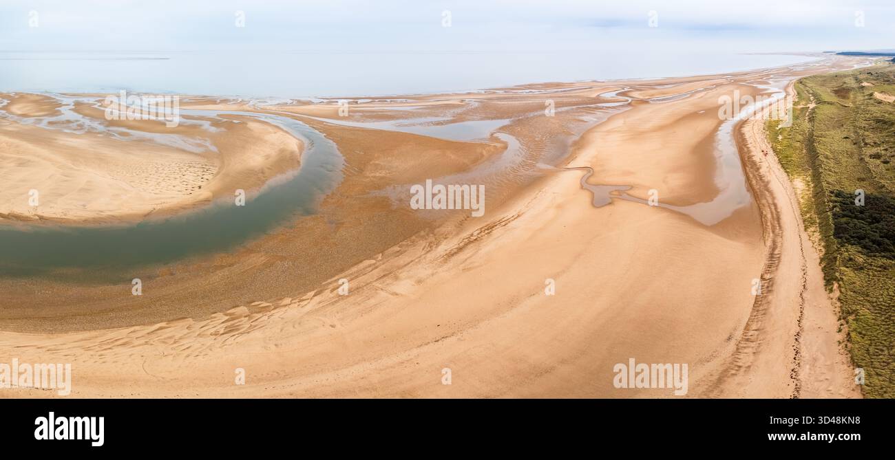An aerial view of the channels of water on the beach during low tide at ...