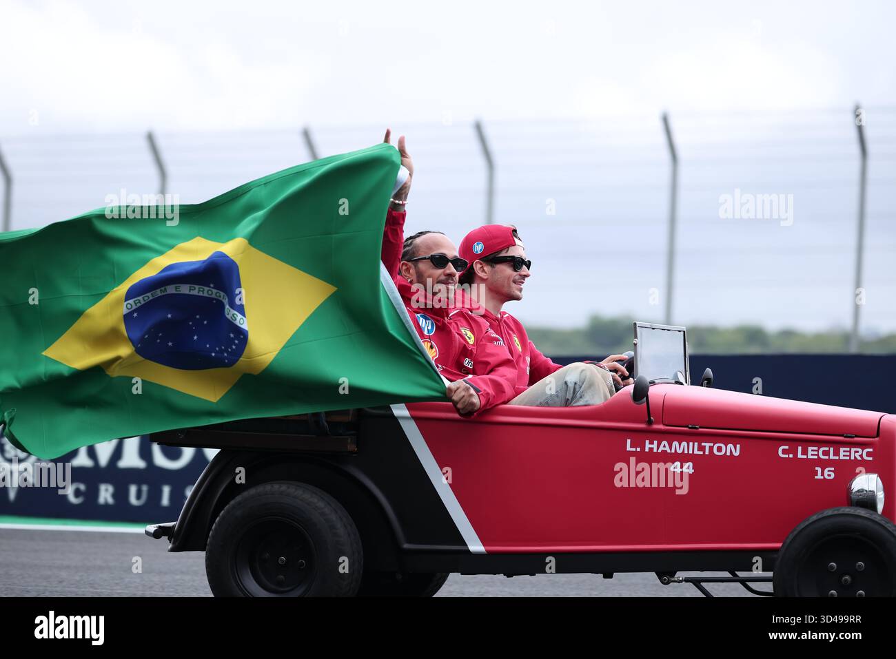 Ferrari driver Lewis Hamilton of Britain, left, waves a Brazilian flag ...