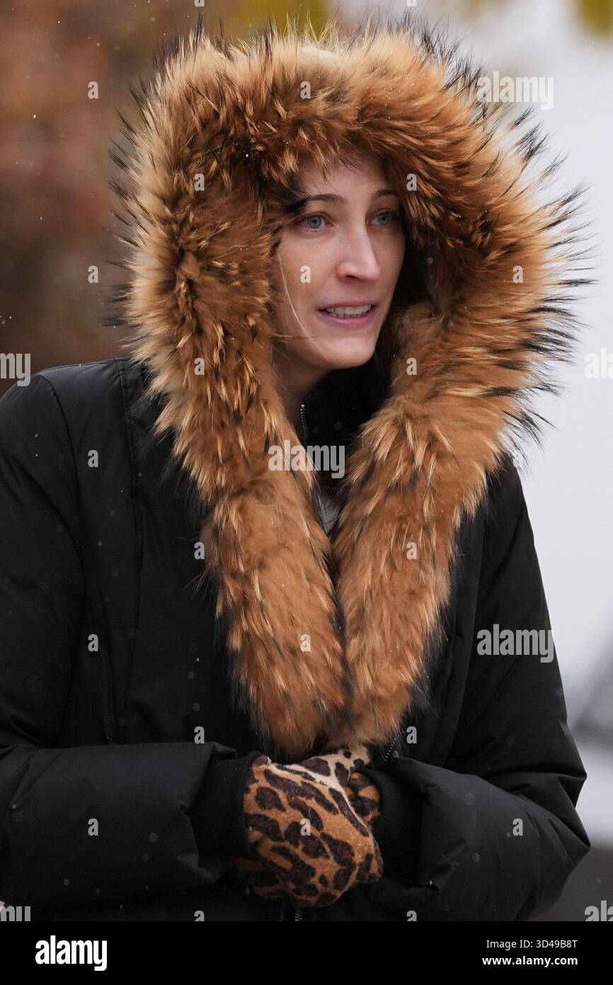A pedestrian bundles up as she walks on the sidewalk during a snowy day ...