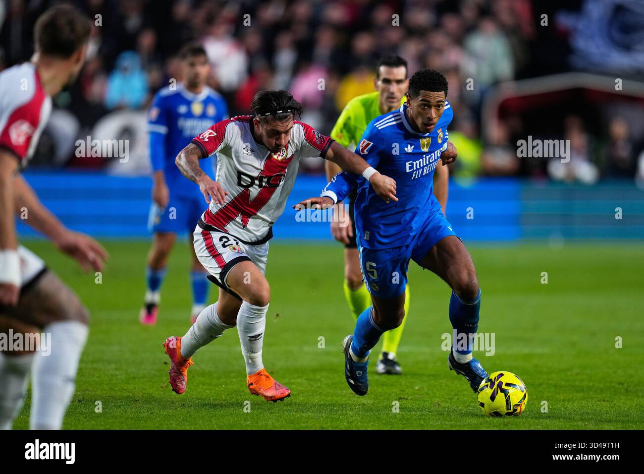 Real Madrid's Jude Bellingham, right, and Rayo's Alfonso Espino vie for ...