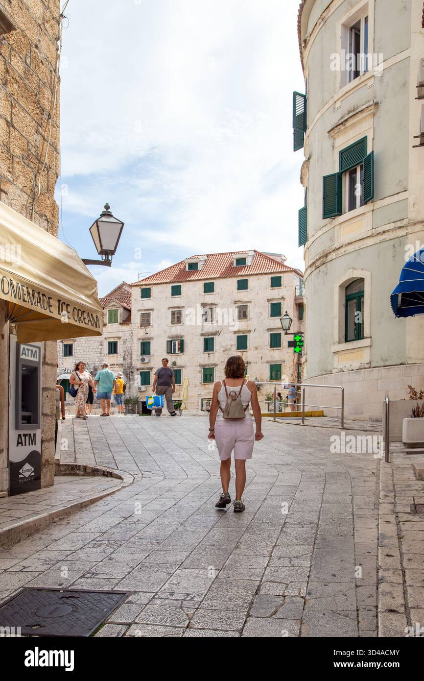 Woman walking into the old town in the Croatian seaside resort of ...