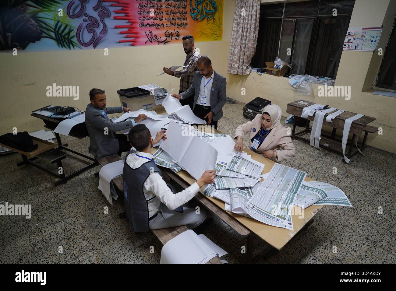 09 November 2025, Iraq, Mosul: Electoral employees count ballots at a ...
