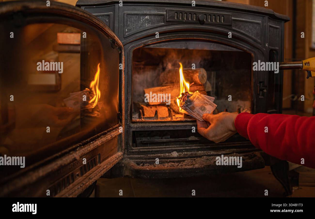 Burning fake US dollar bills inside a cast iron fireplace as concept of ...
