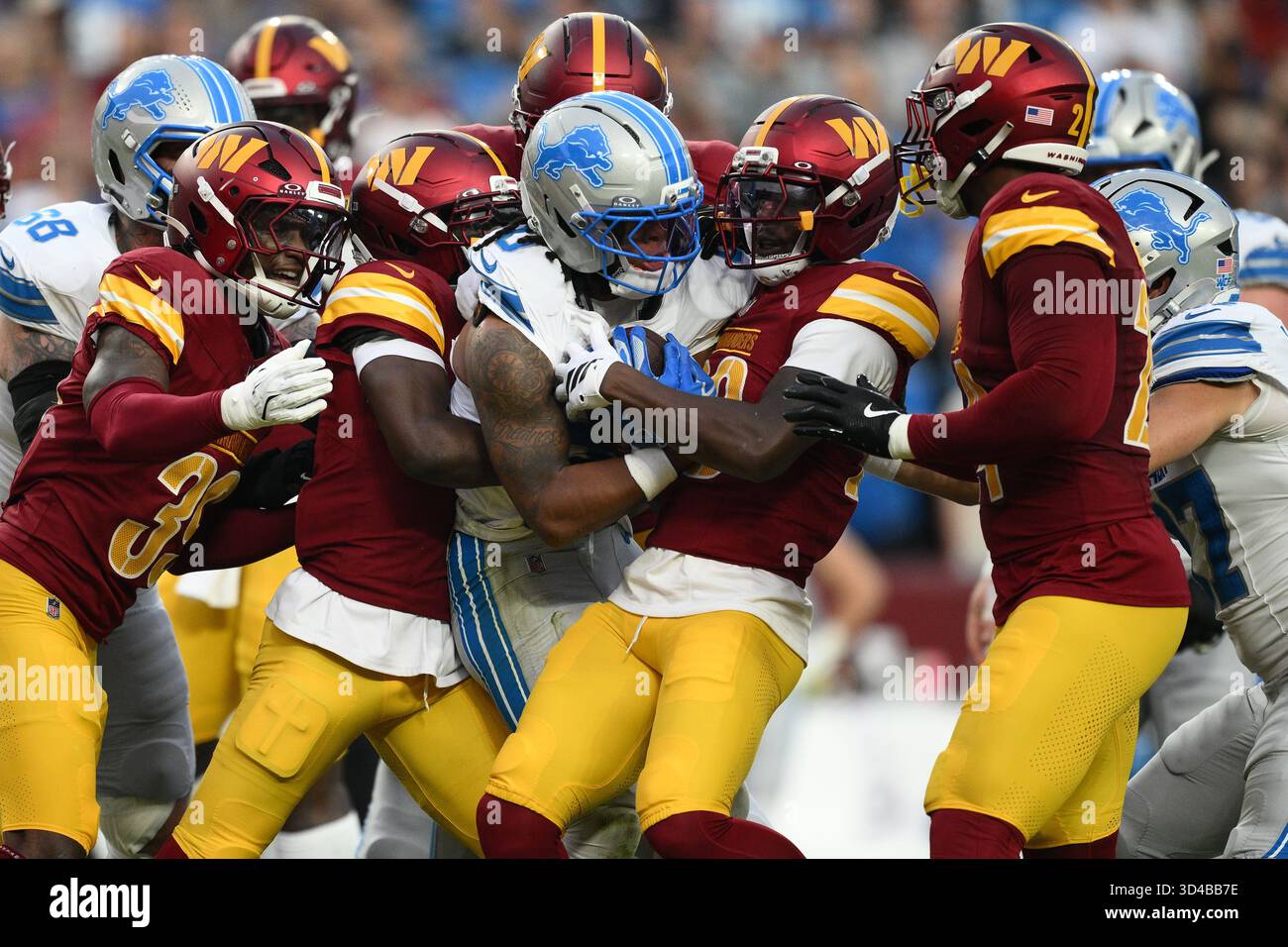 Detroit Lions running back Jahmyr Gibbs (0) is stopped by a host of ...