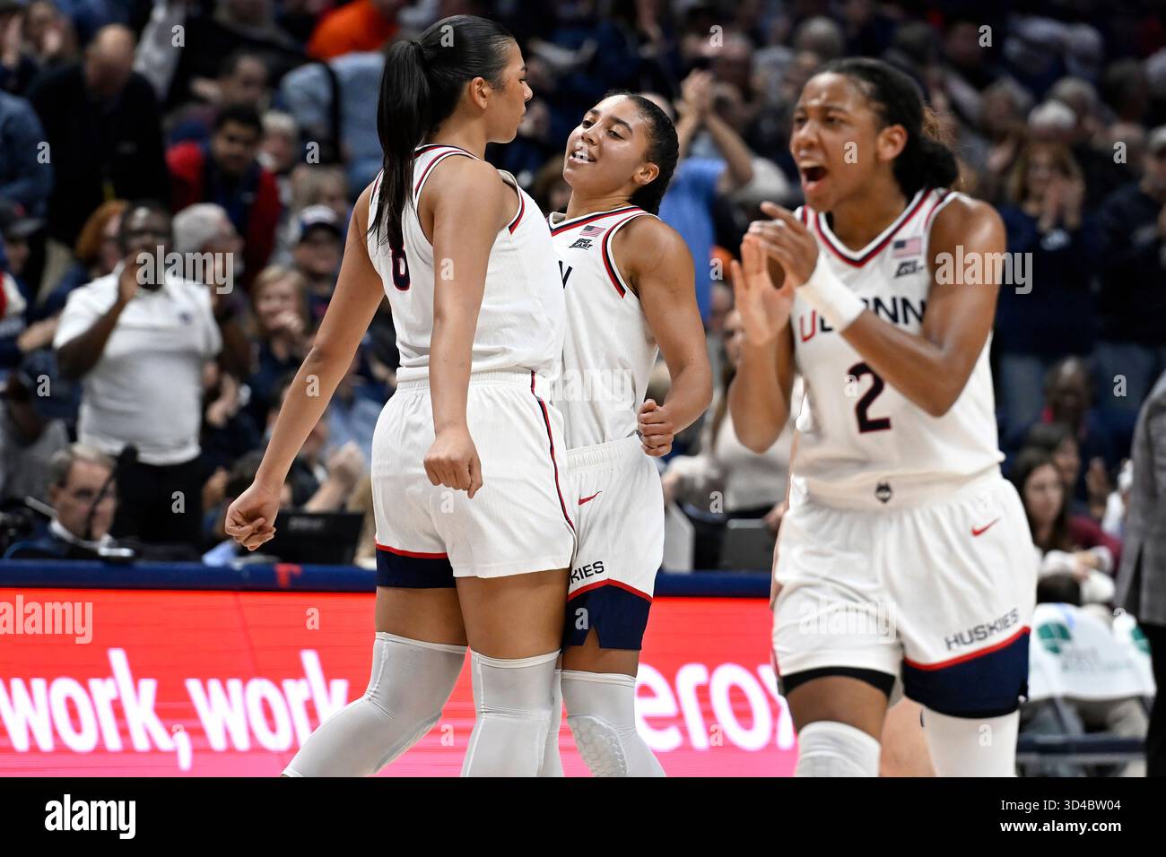 UConn center Jana el Alfy, left, chest-bumps with guard Azzi Fudd in the first half of an NCAA ...