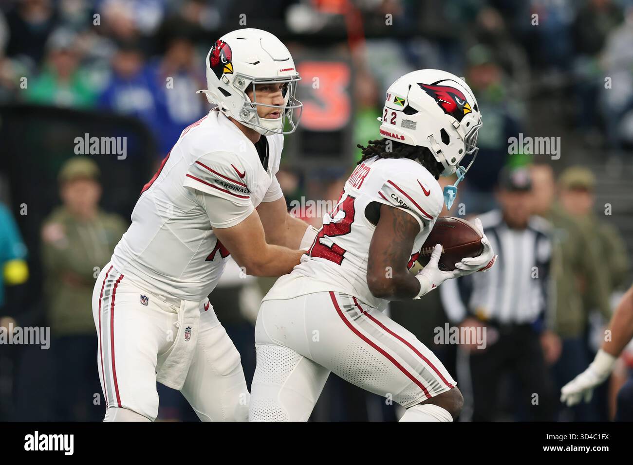 Arizona Cardinals quarterback Kedon Slovis, left, hands the ball off to ...