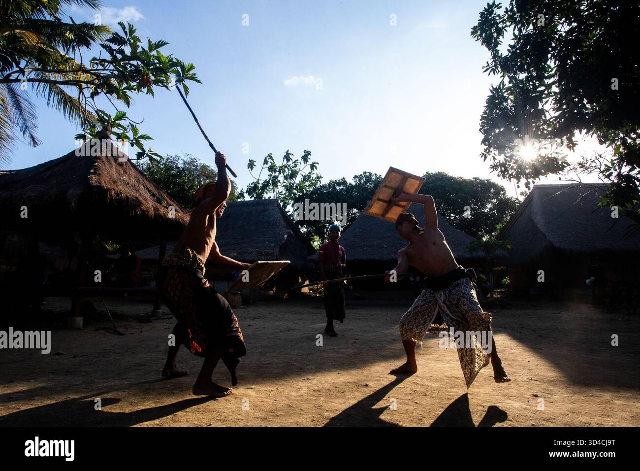 Two Sasak men engage in Peresean, a traditional stick-fighting in ...