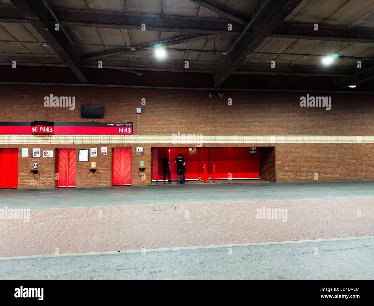 Manchester, UK - September 30, 2025: Visitors stand near bright red ...