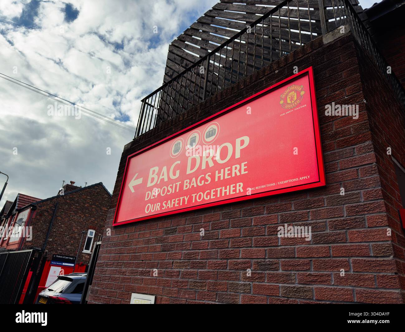 Manchester, UK - September 30, 2025: Bright red bag drop sign on brick ...