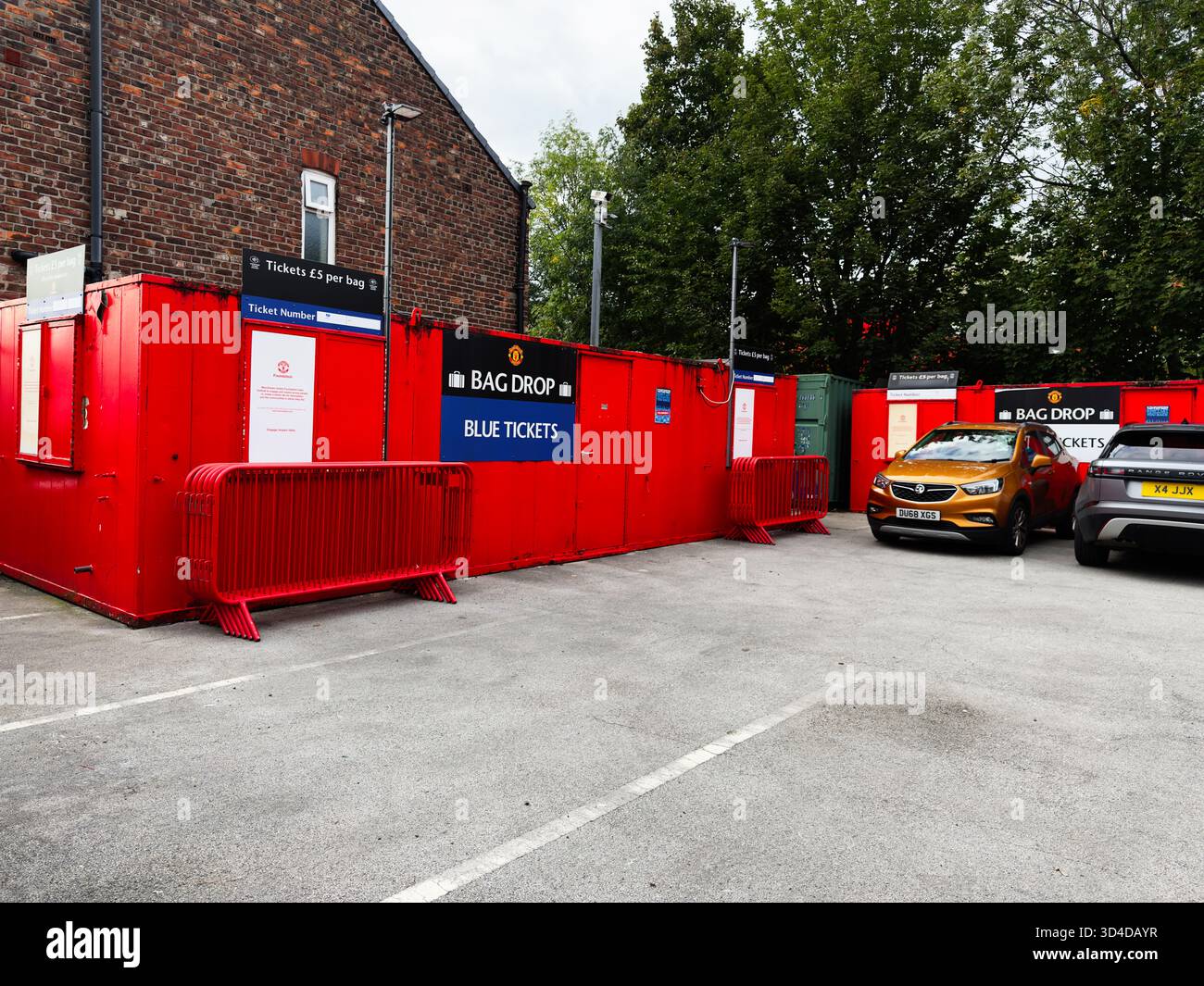 Manchester, UK - September 30, 2025: Bright red barriers define a bag ...