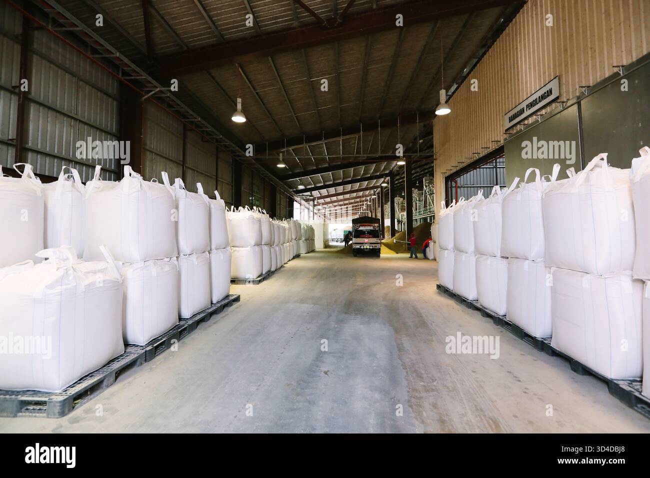 Rows of large white bulk bags filled with processed rice neatly ...
