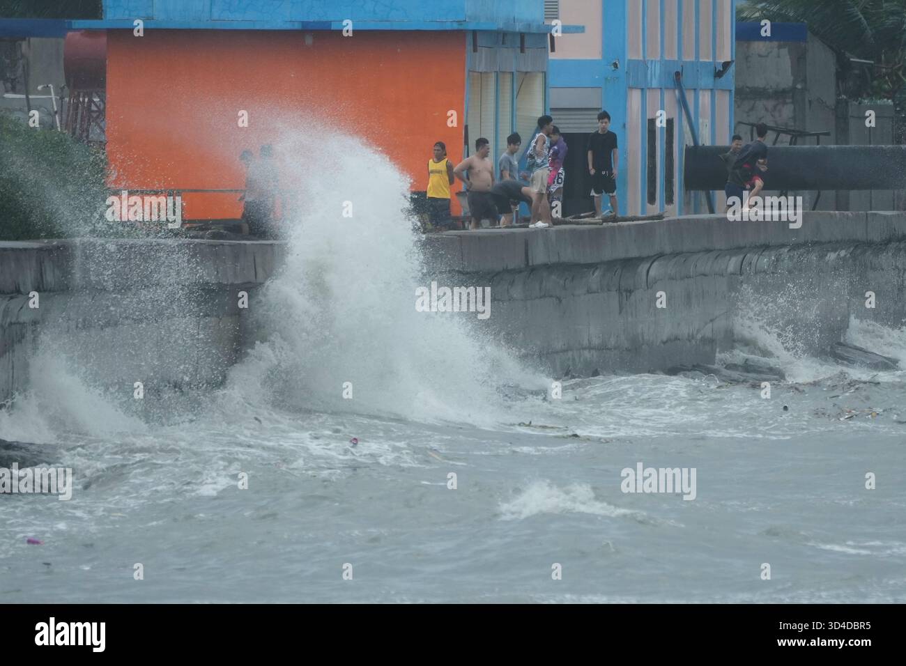 People stand as strong waves due to Typhoon Fung-wong hit the seawall ...