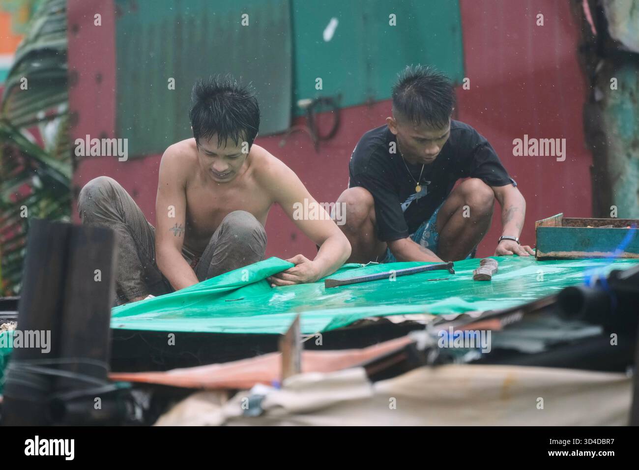 Residents reinforce their roof as strong winds due to Typhoon Fung-wong ...