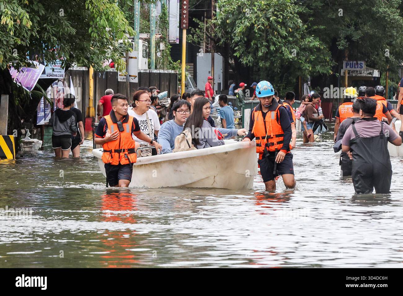 Navotas City, Philippines. 10th Nov, 2025. Rescuers use a boat to ...