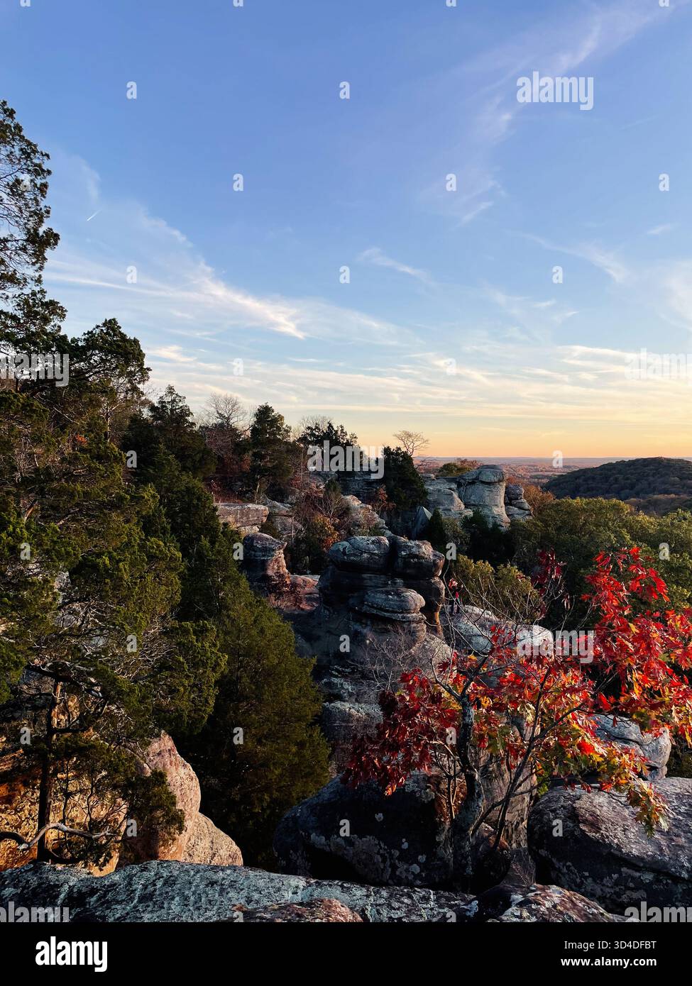 Dramatic sandstone spires at dusk with autumn foliage and expansive sky ...
