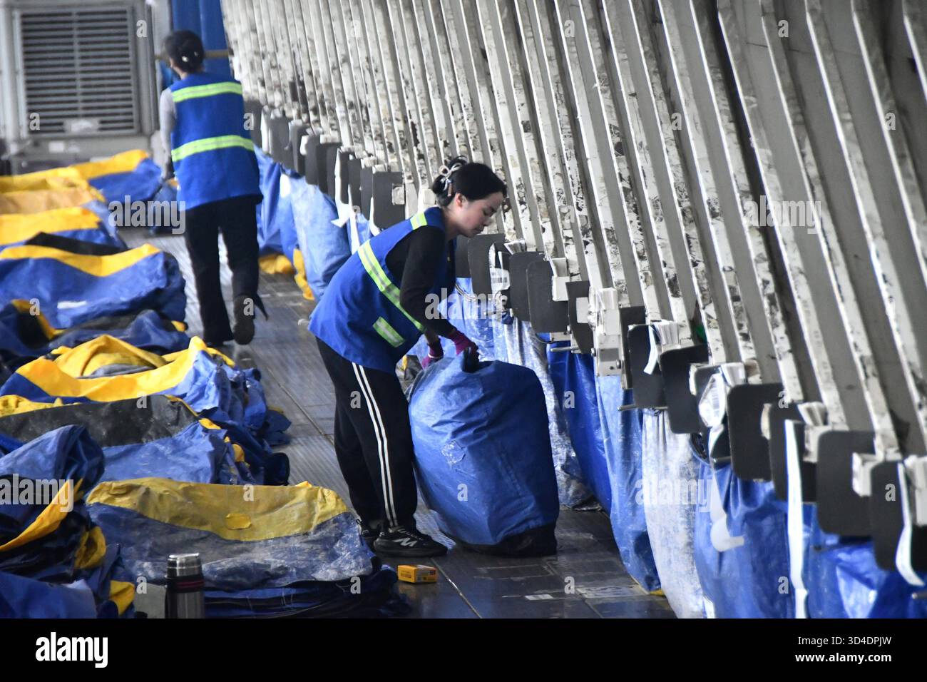 Staff are sorting express packages at the ZTO Express transfer center ...