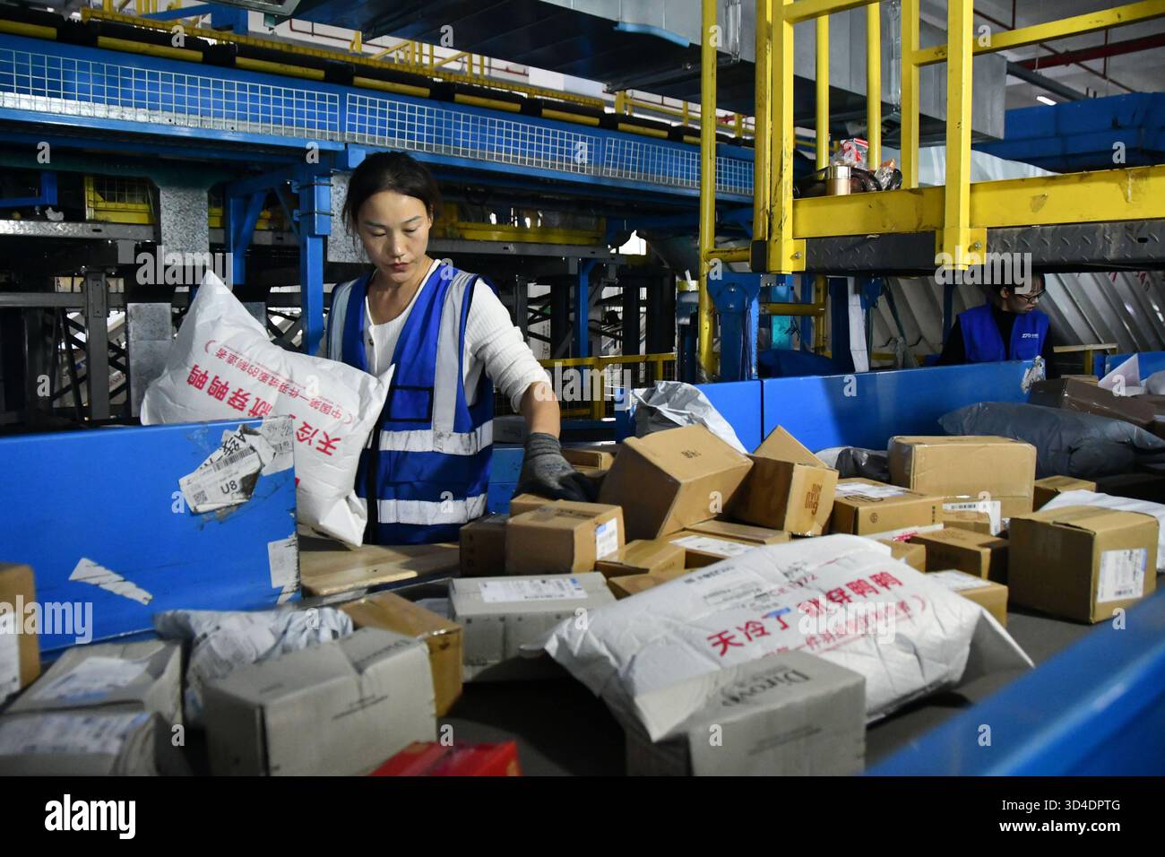 Staff are sorting express packages at the ZTO Express transfer center ...