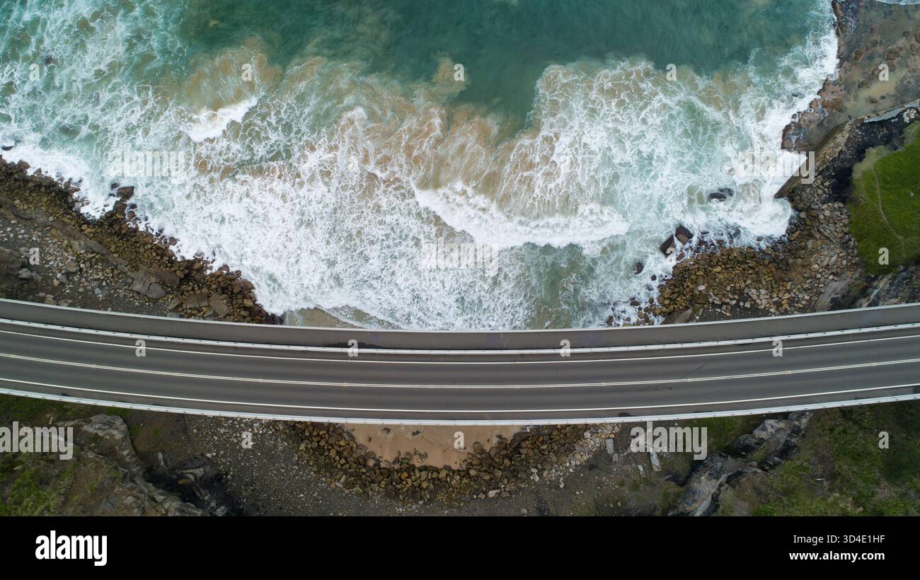 Aerial view of the Sea Cliff Bridge's graceful curve against the rugged ...