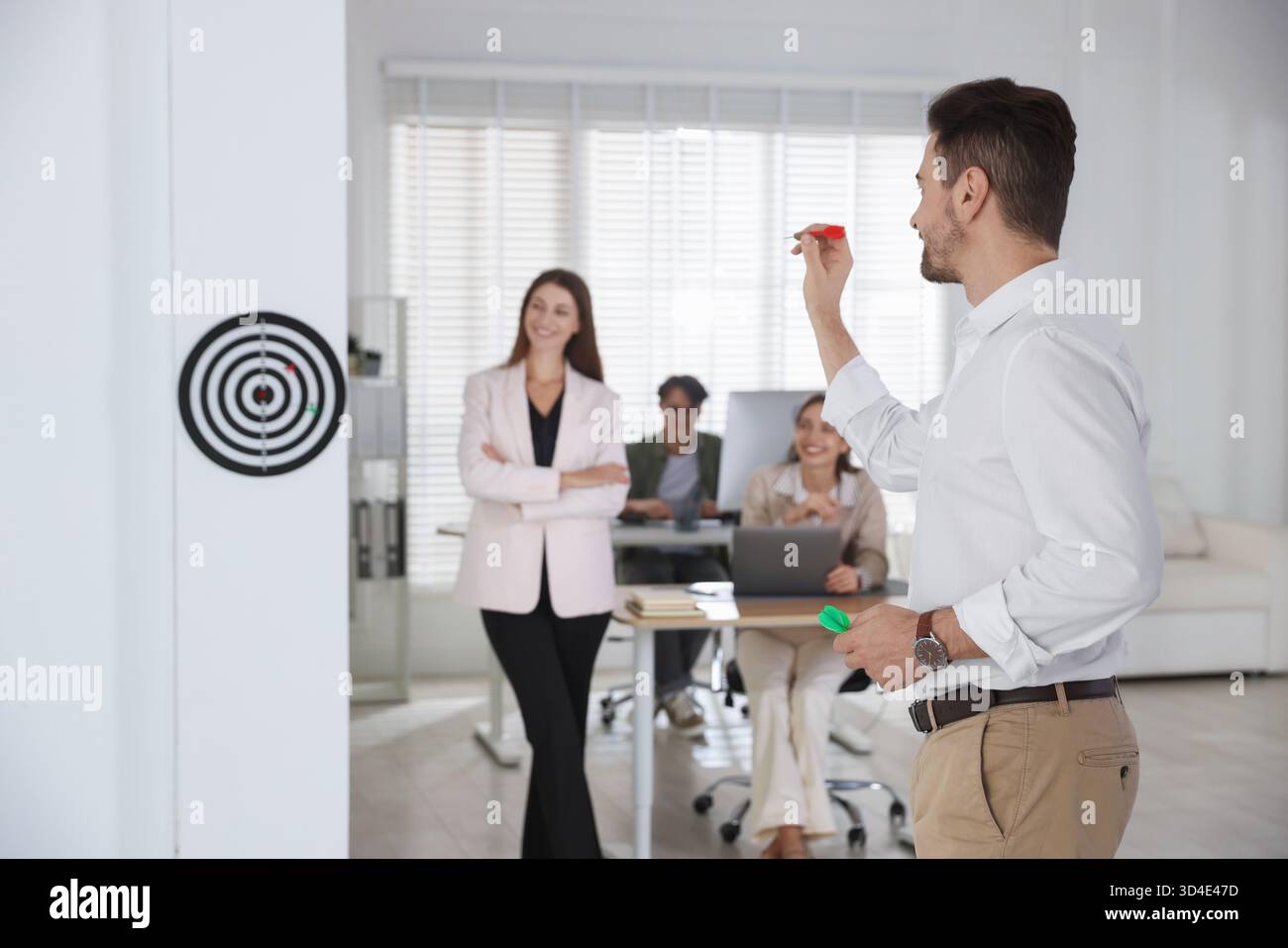 Group of colleagues playing darts in office, selective focus Stock ...