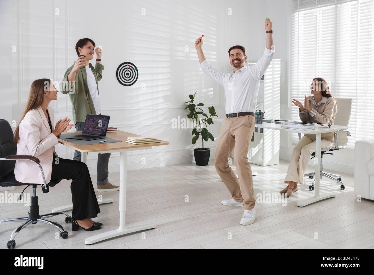 Group of colleagues playing darts in office Stock Photo - Alamy