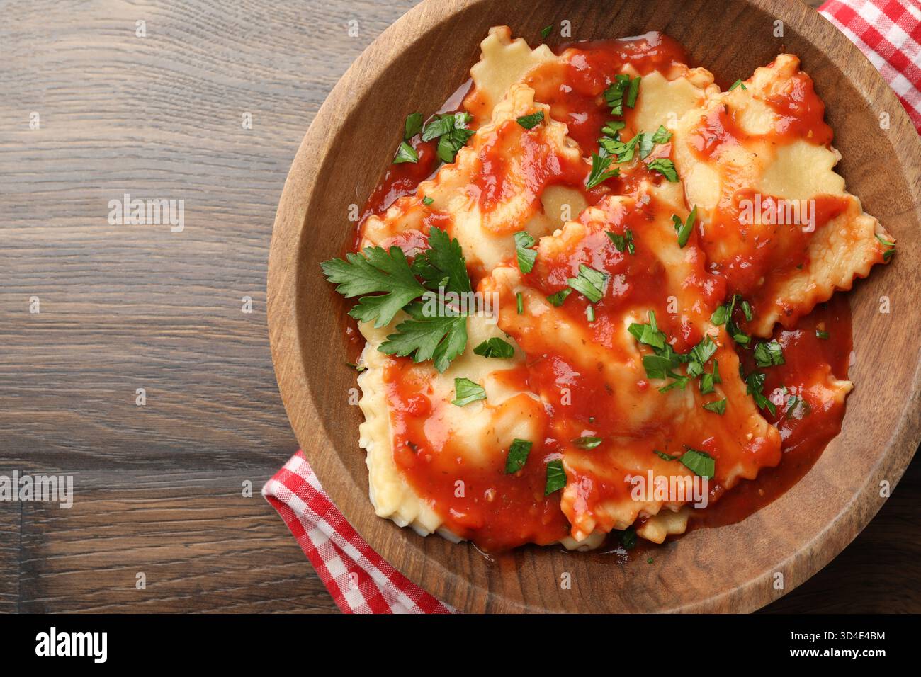 Delicious ravioli with tomato sauce and parsley on wooden table, top ...