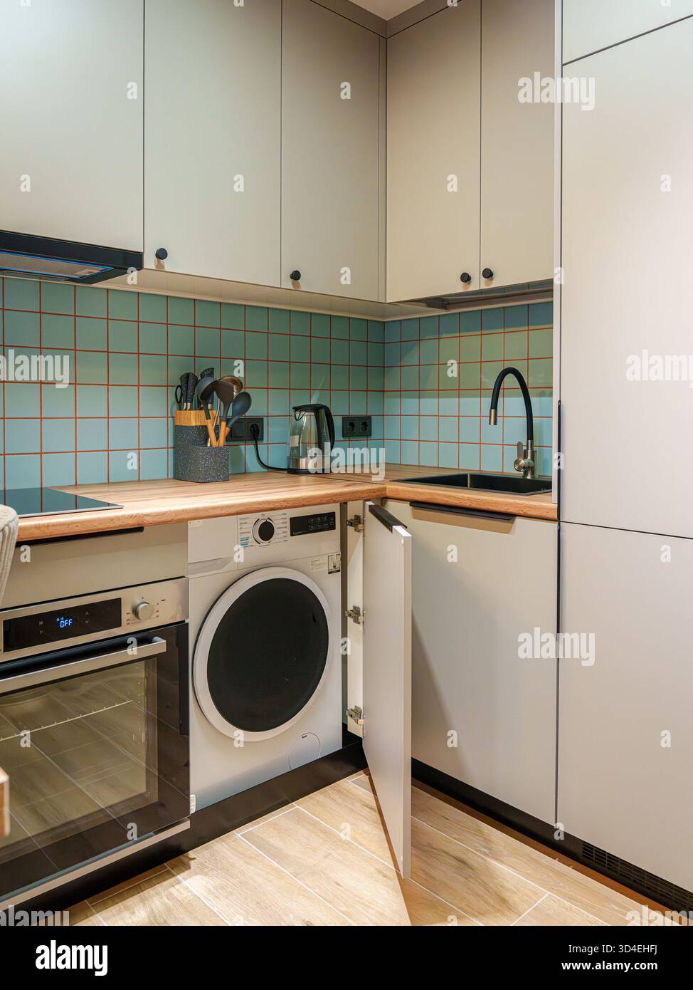 Compact Modern Kitchen with Built In Appliances and Light Wood Finishes ...