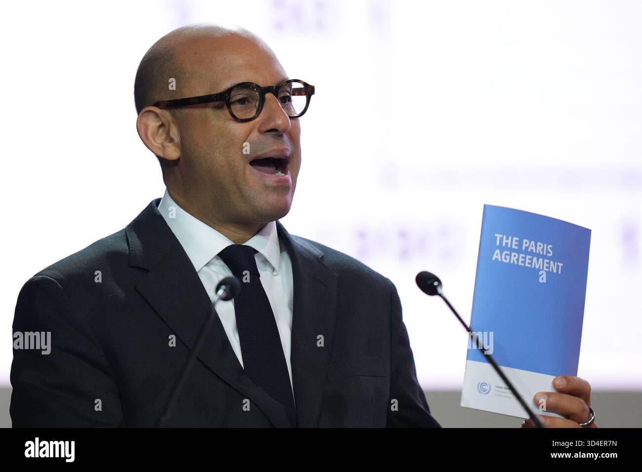 Simon Stiell, United Nations climate chief, holds up a pamphlet that ...